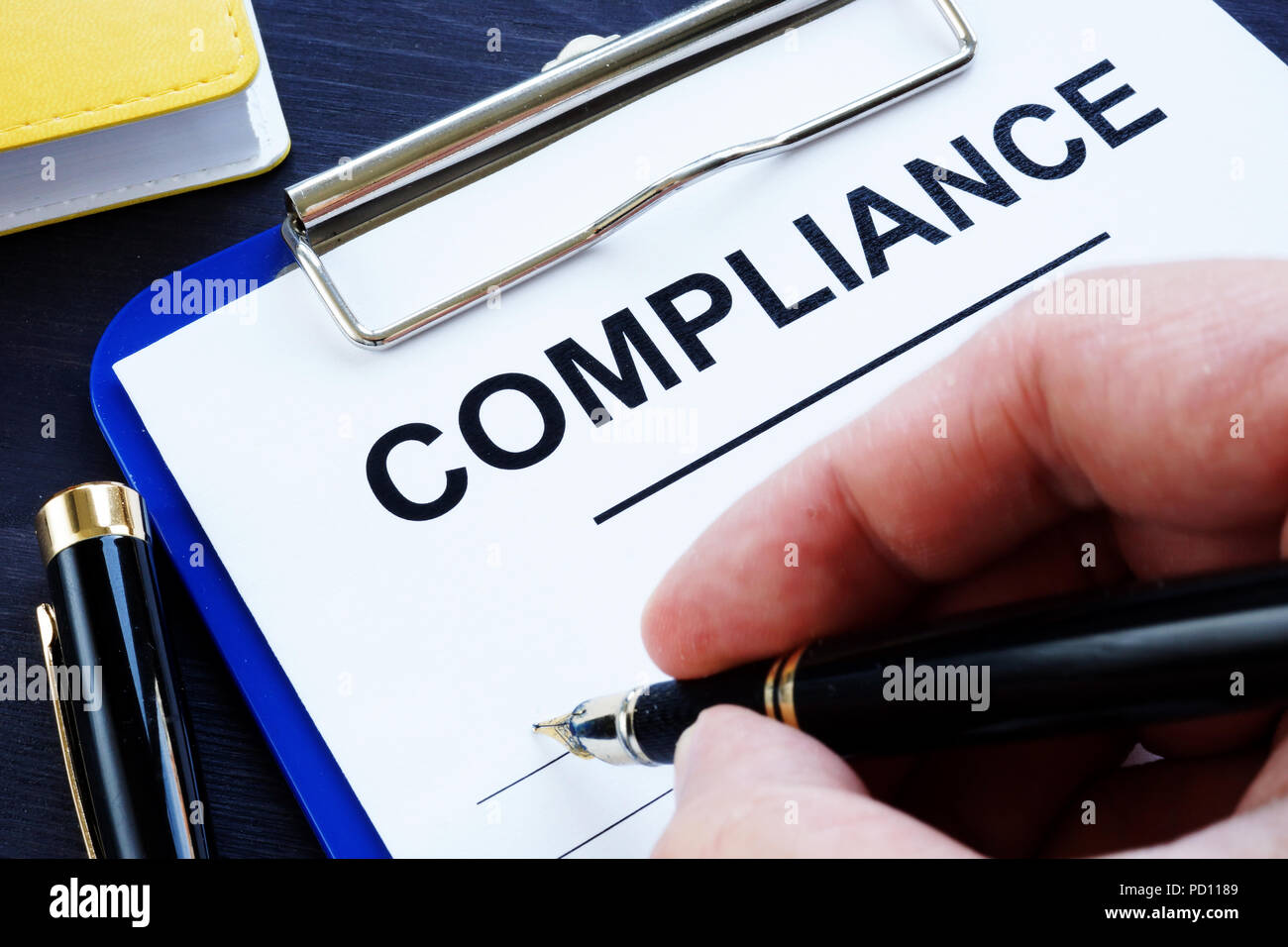 Man is filling in a compliance form Stock Photo - Alamy