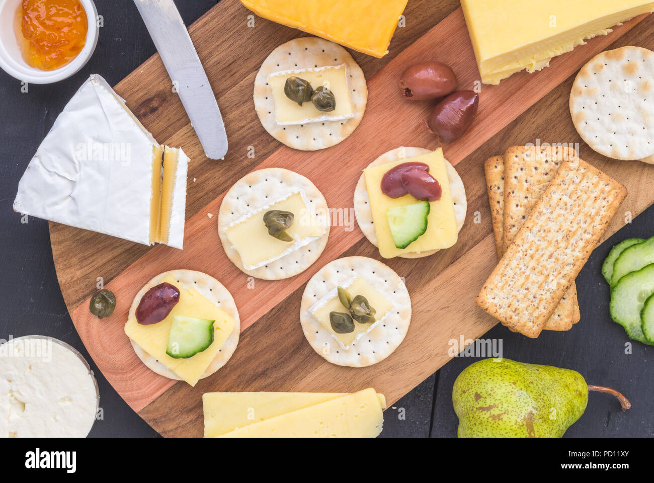 Cheese board with assorted cheese, and crackers on wooden board - top ...