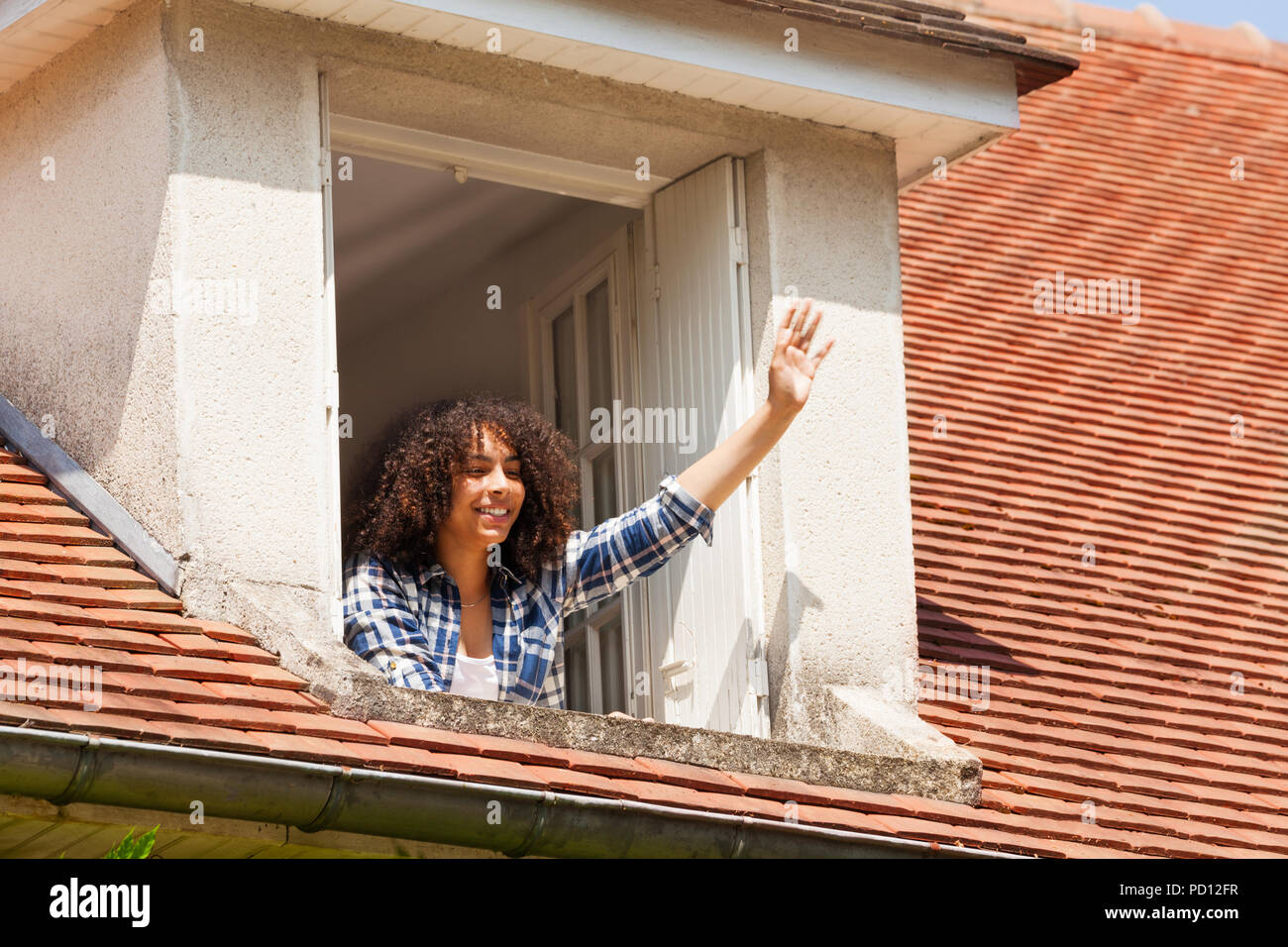 Girl waving hand while looking out the window Stock Photo - Alamy