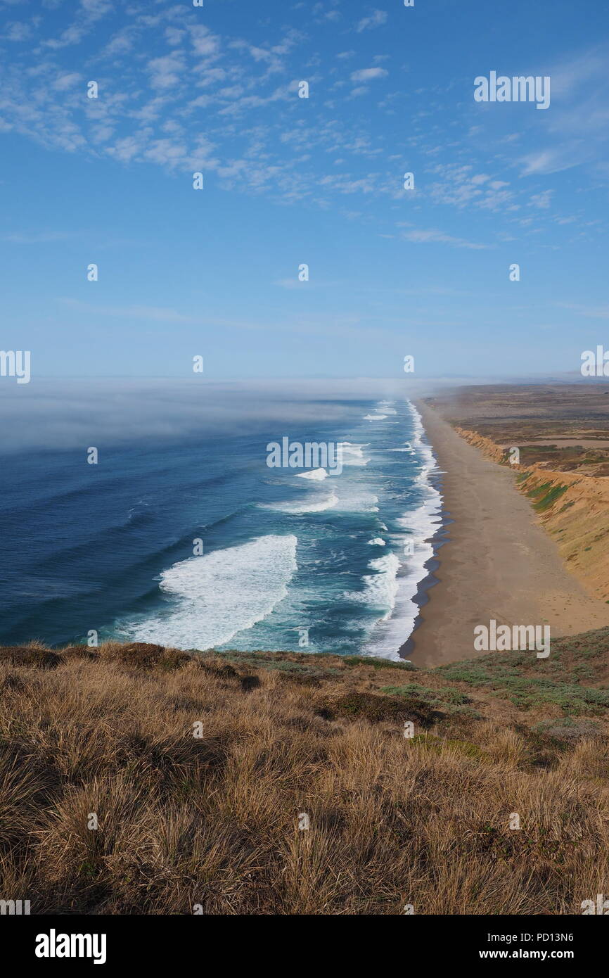 Looking down at the waves breaking onto the beach at Point Reyes ...