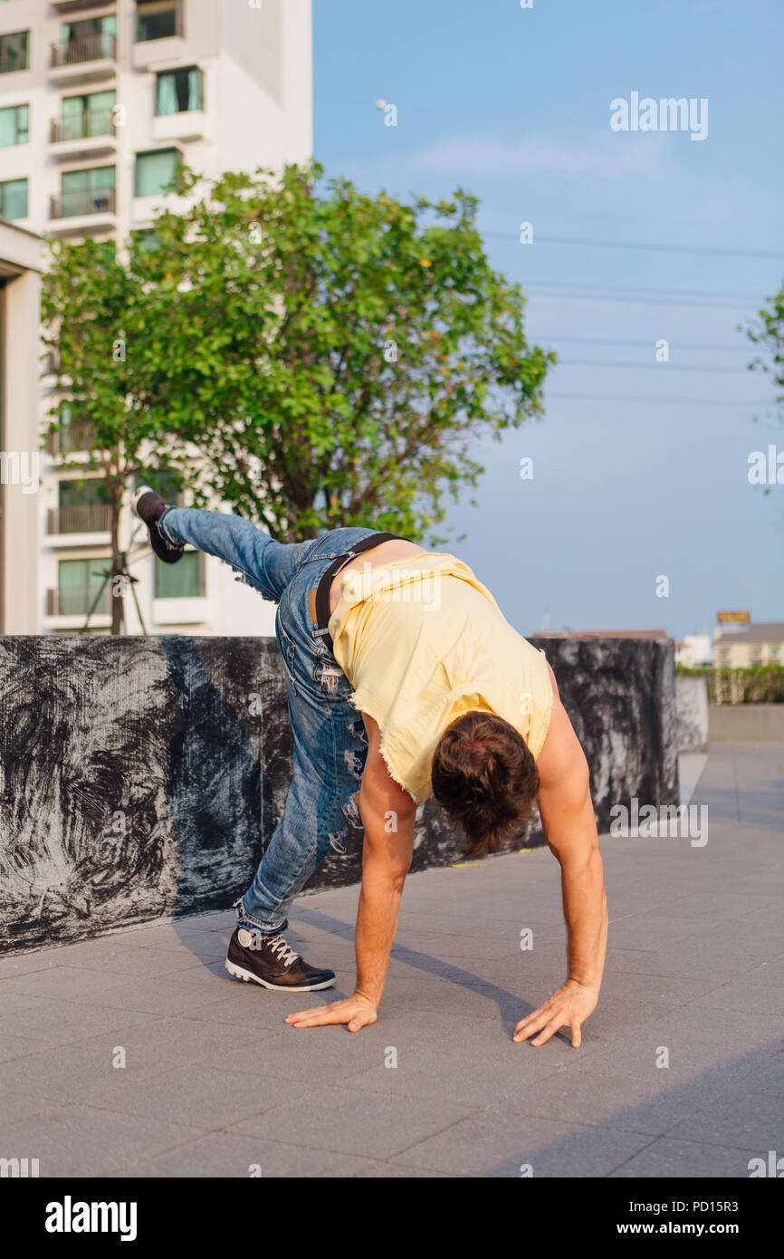 Young handsome man with beard dancing breakdance on the street. Man ...