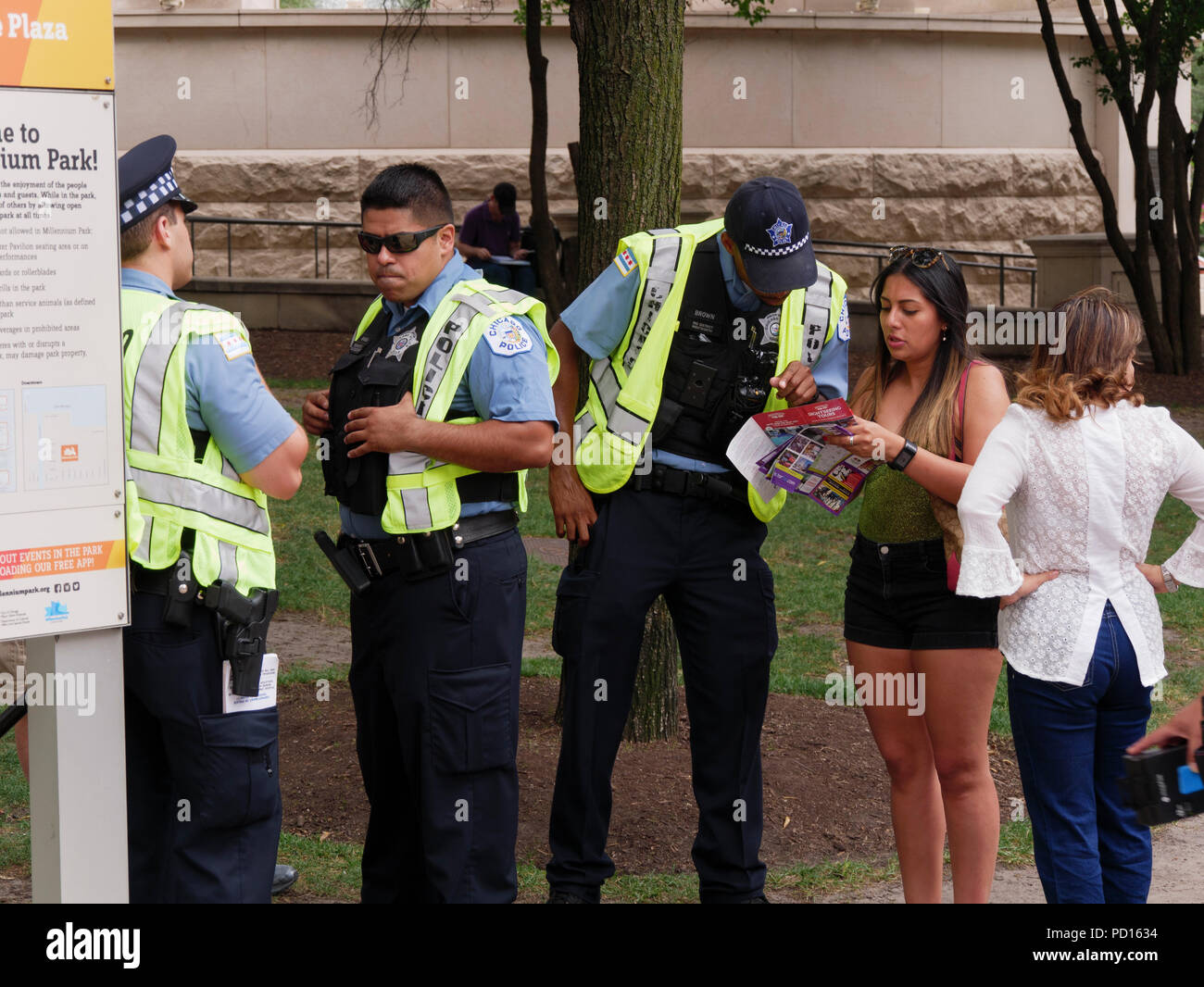 Three Chicago Police officers, one giving directions to women in ...