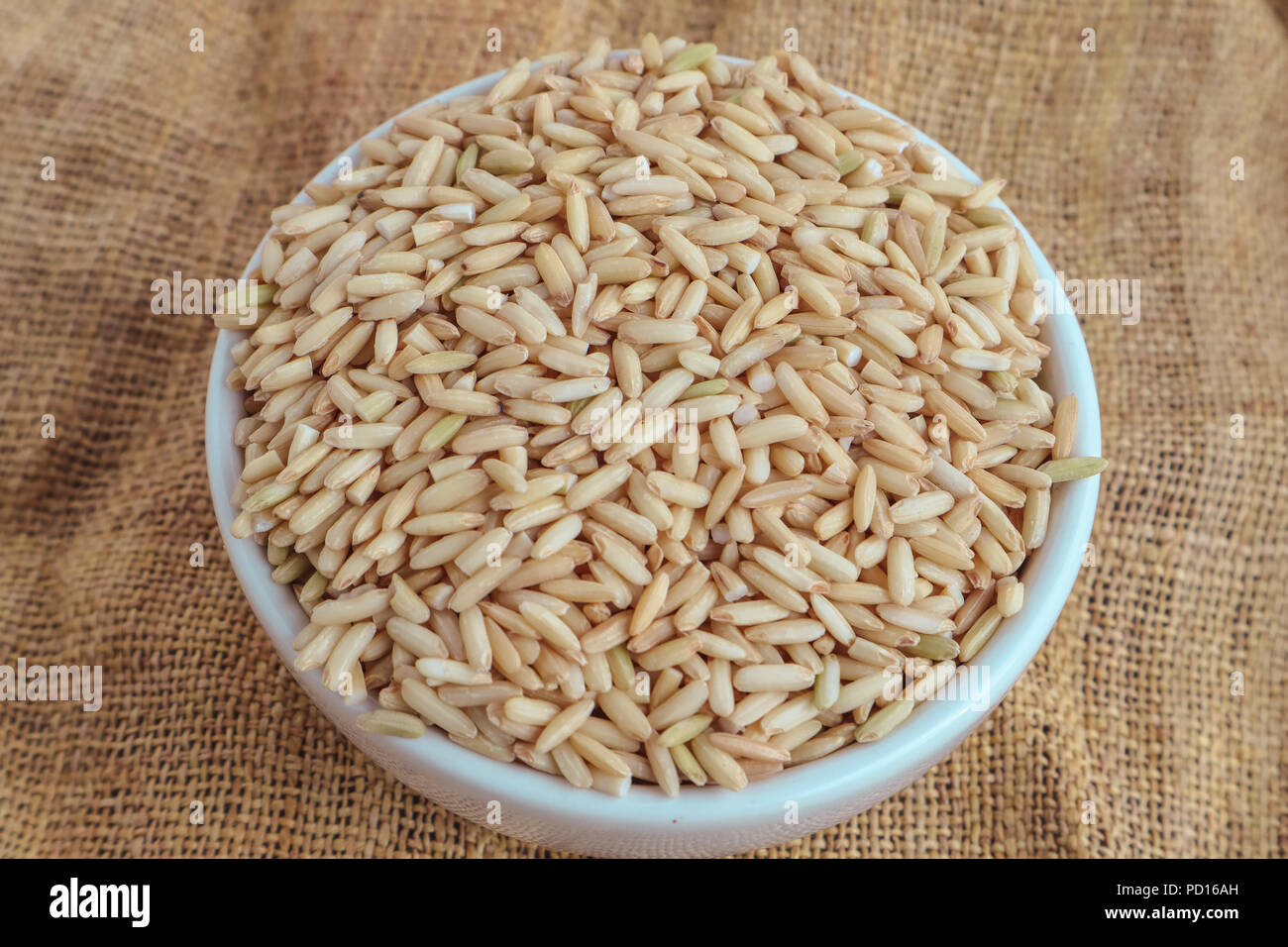 Raw brown rice in a bowl. top view food background Stock Photo - Alamy