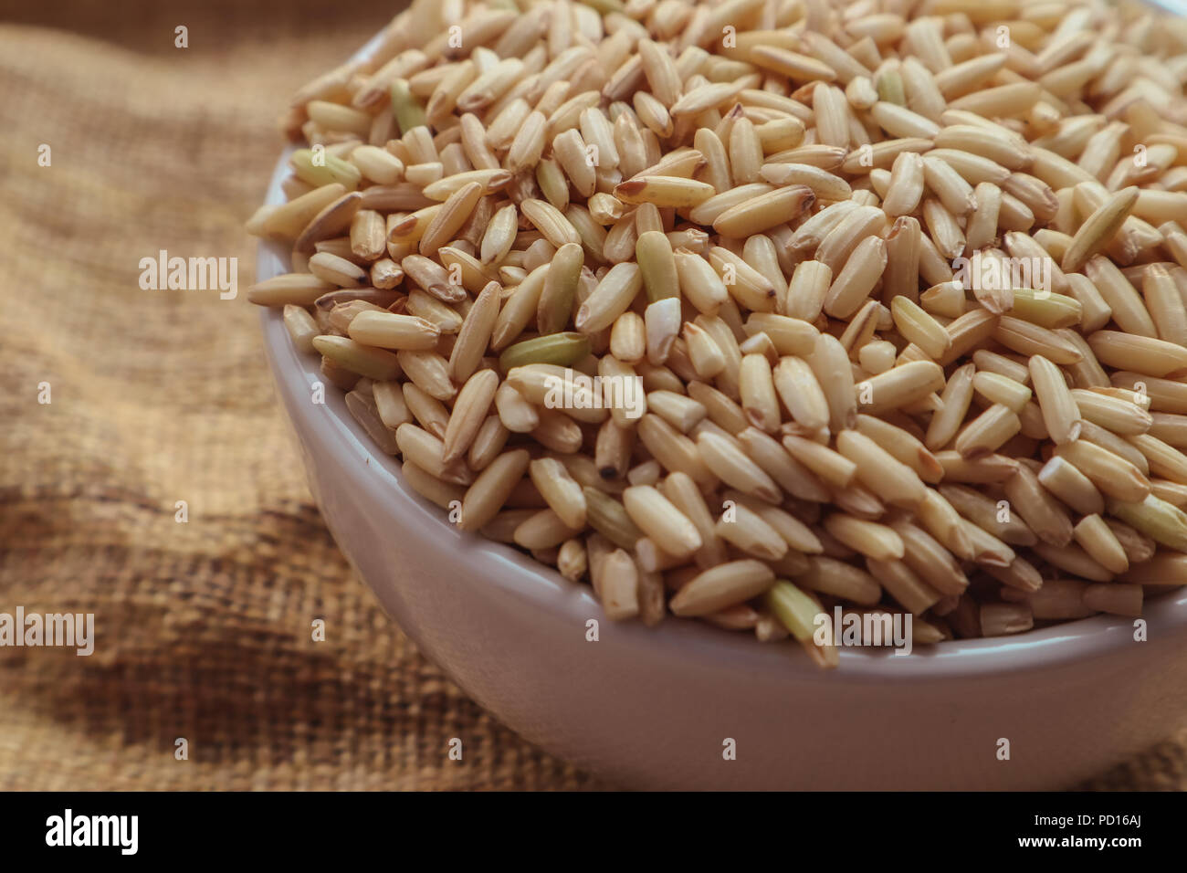 Raw brown rice in a bowl. top view food background Stock Photo - Alamy