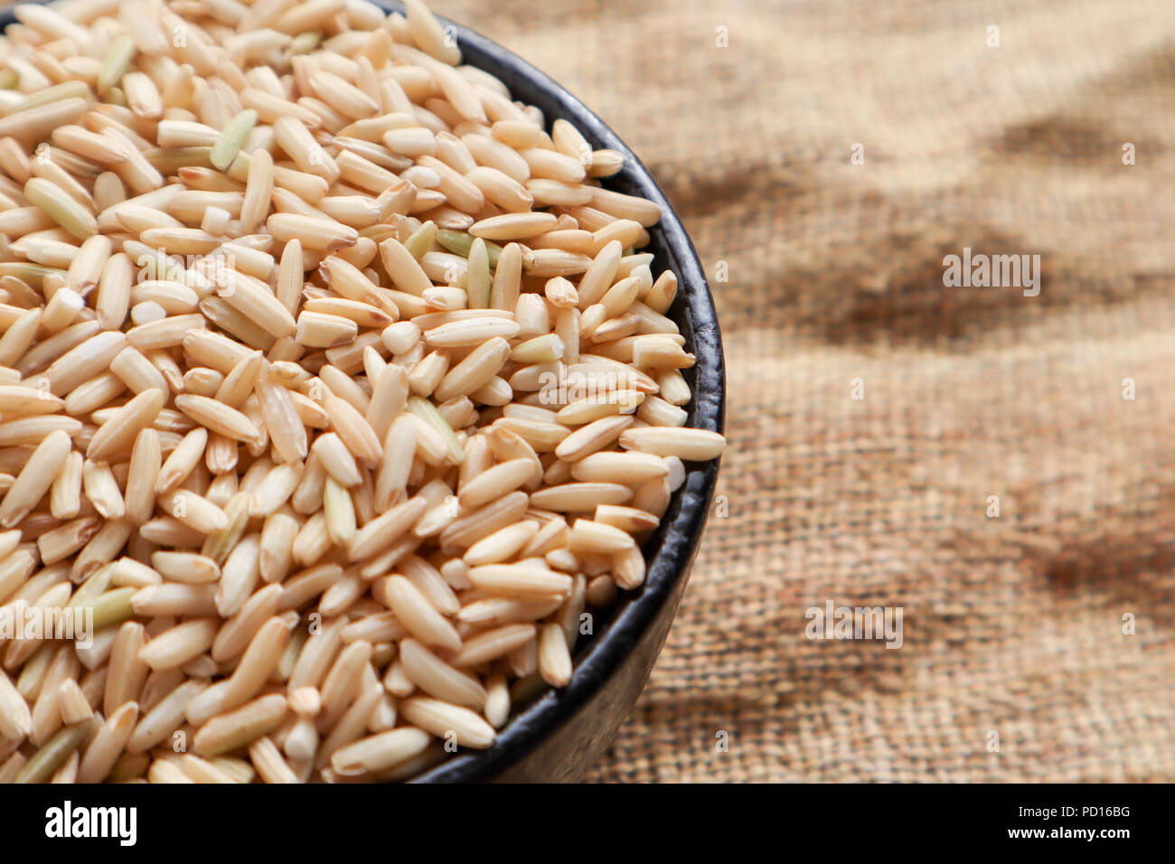 Raw brown rice in a bowl. top view food background Stock Photo - Alamy