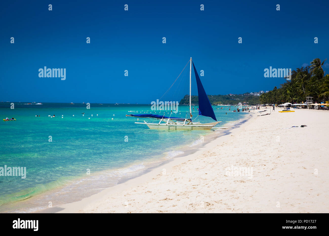 Philippine traditional boat with blue sail on White Beach. Boracay ...