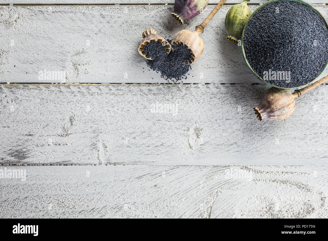 Poppy seed with their heads on wooden boards Stock Photo - Alamy