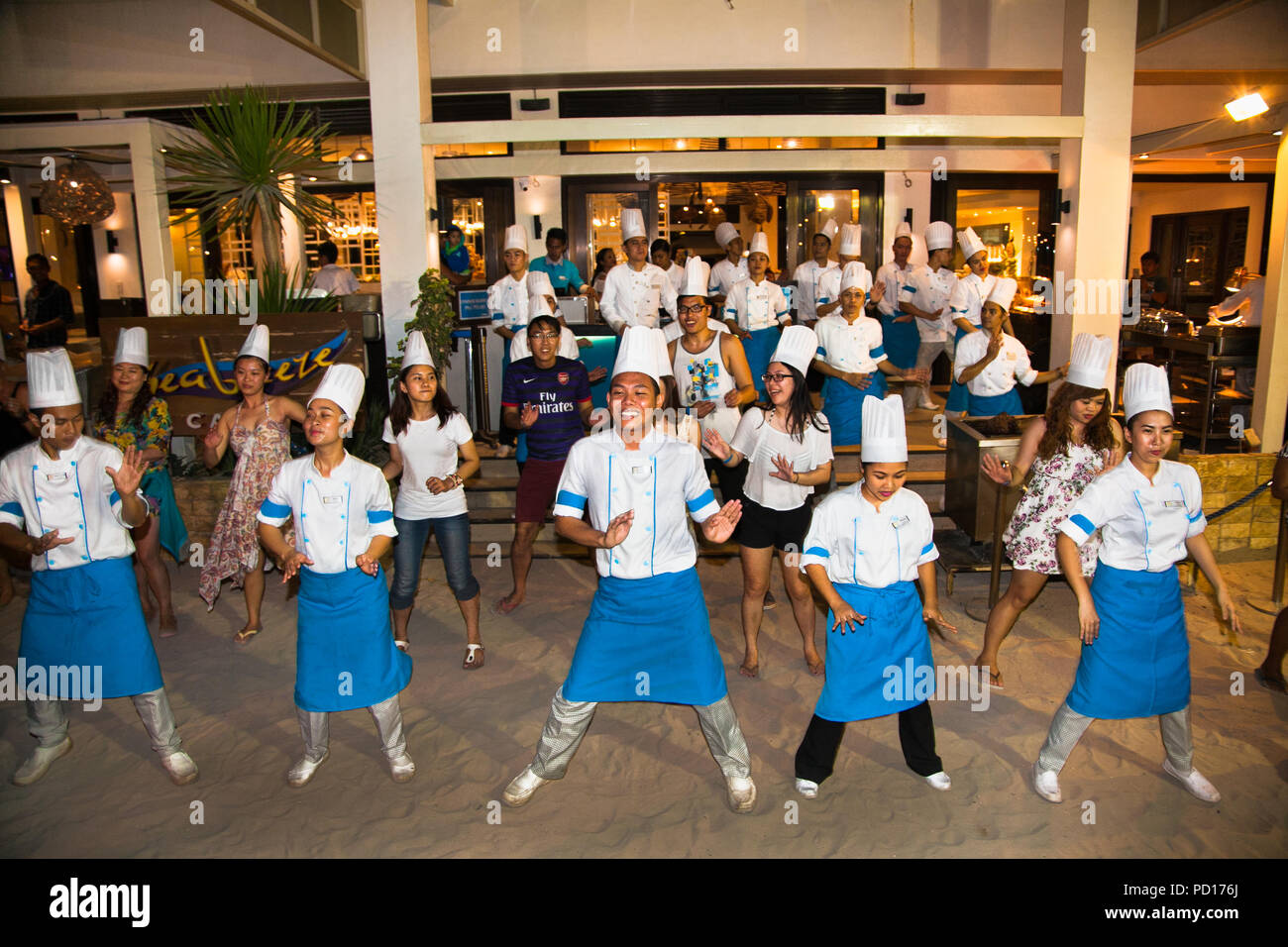 BORACAY, PHILIPHINES-MARCH 19, 2016:Group of chefs dancing in frot of a ...