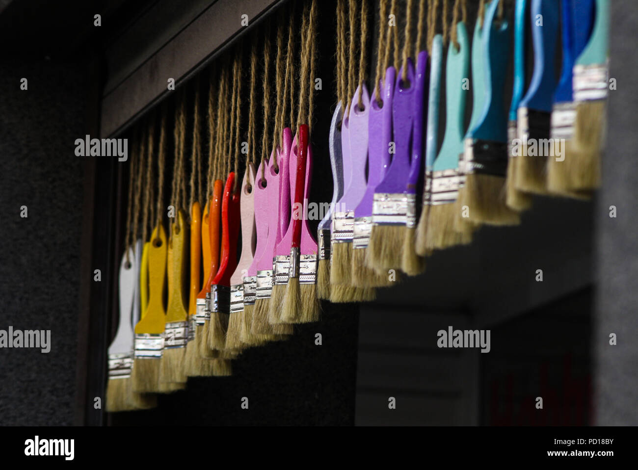 Rainbow colored brushes hanging on strings Stock Photo - Alamy