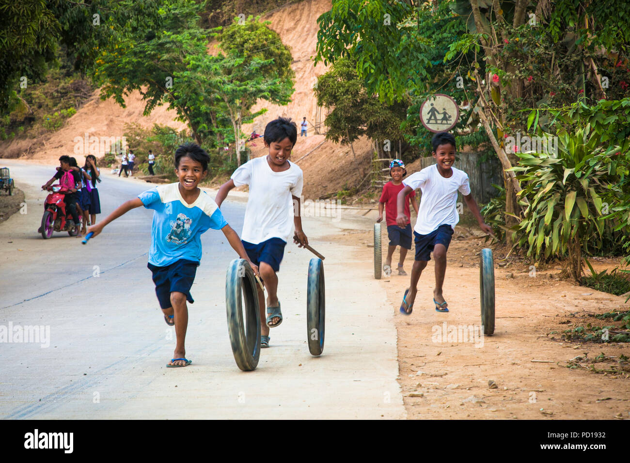 PALAWAN, PHILIPPINES-MARCH 28, 2016: Kids are playing with used tire in ...