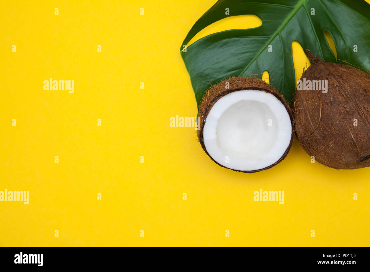 Tropical summer coconut background. half and whole coconuts on a yellow ...