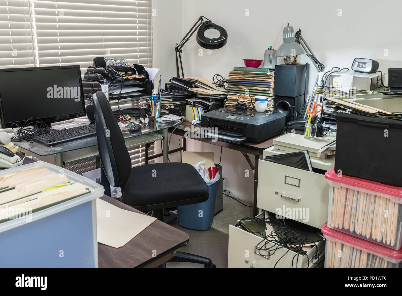 Messy business office desk with boxes of files and disorganized clutter ...
