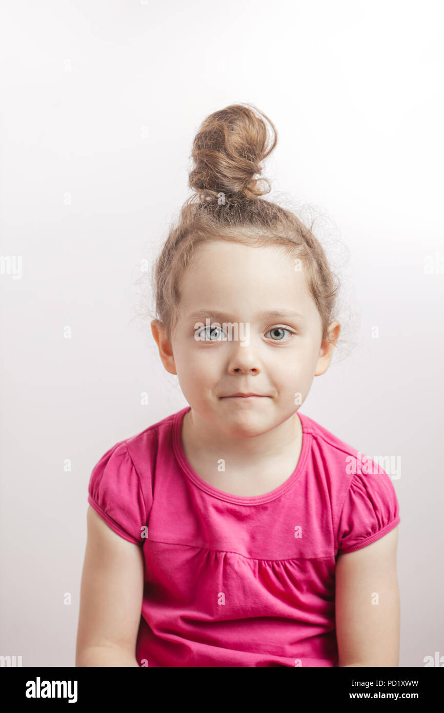 shy ginger girl with bun. pleasant beautiful little girl trying not to ...