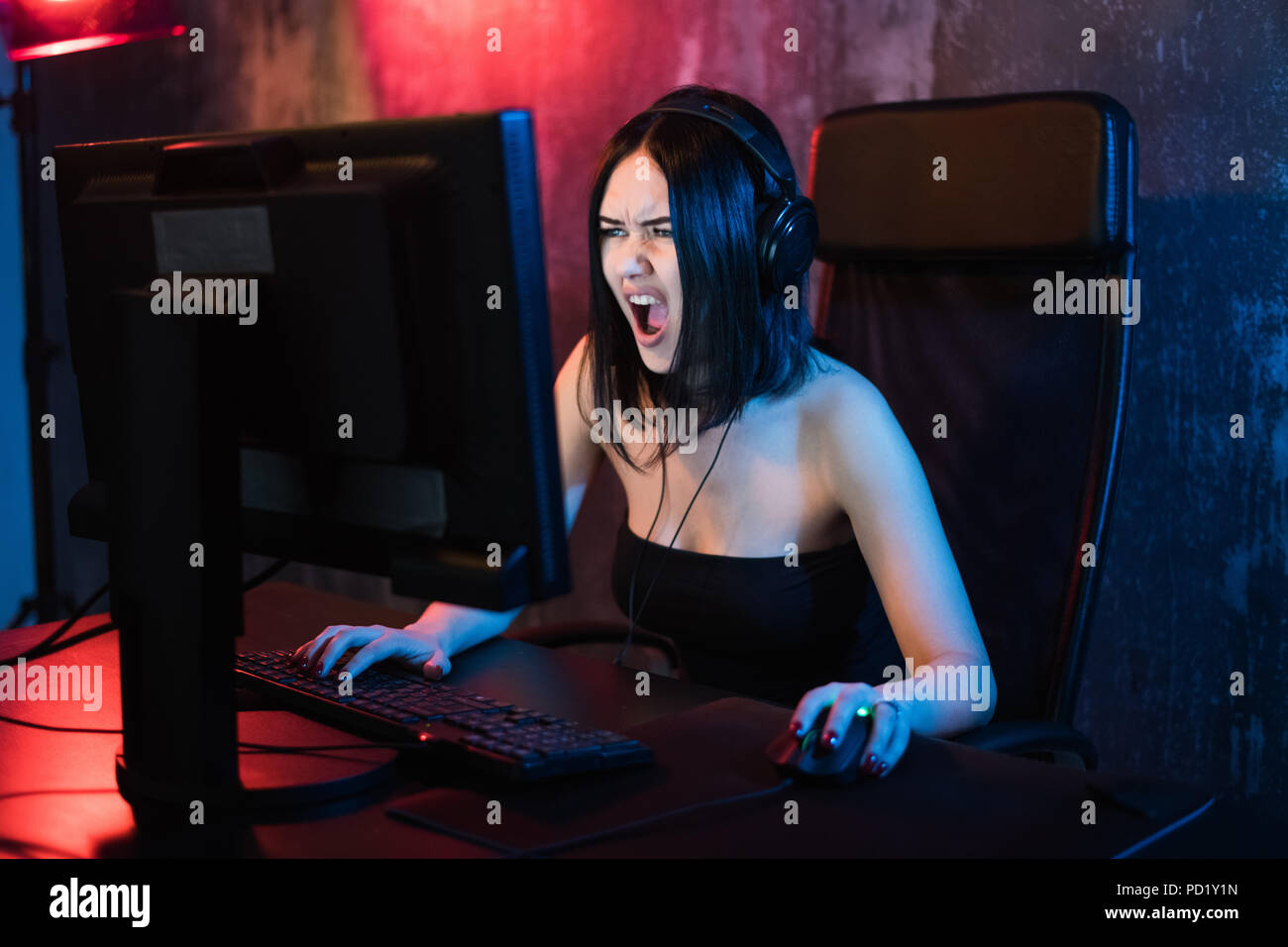 Screaming emotional young angry woman playing on personal computer ...