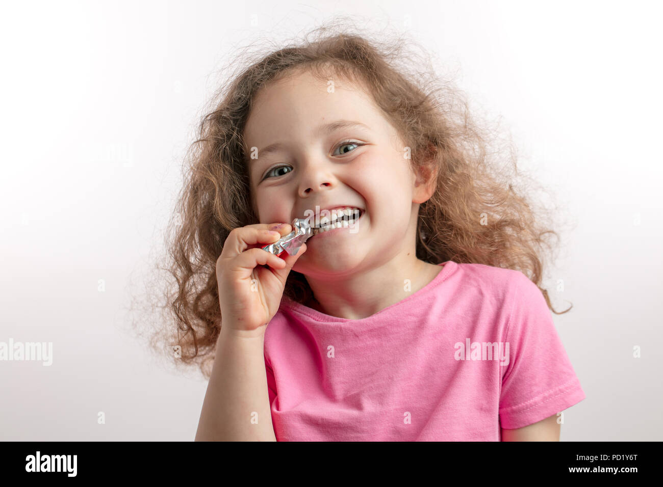 little smiling girl likes chocolate. isolated white background. copy ...