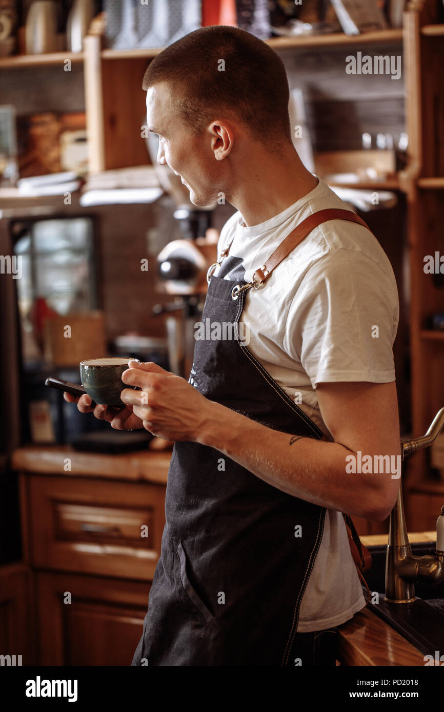 close up back view photo of cheerful waiter with a cup of coffee and a ...