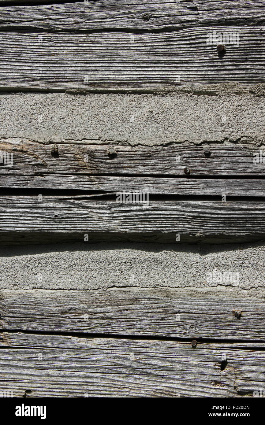 A full frame closeup view of a log cabin construction with mud infill ...