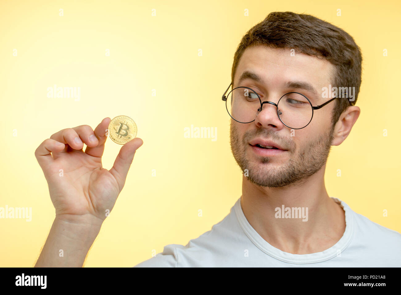 curious handsome guy with golden coin. talisman concept Stock Photo - Alamy