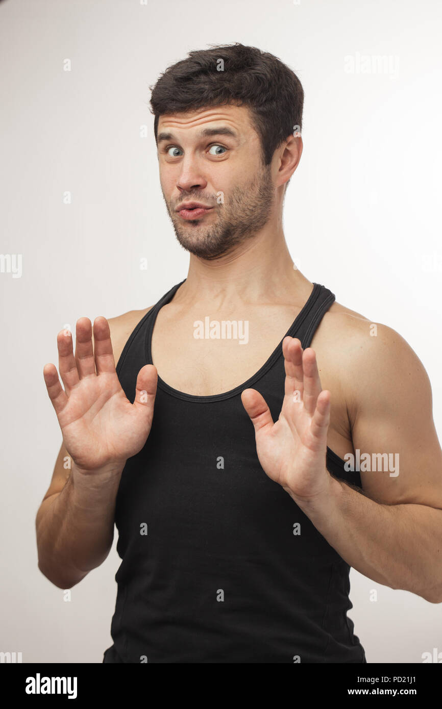 sporty man showing calming down sign. fear concept. please. take it ...