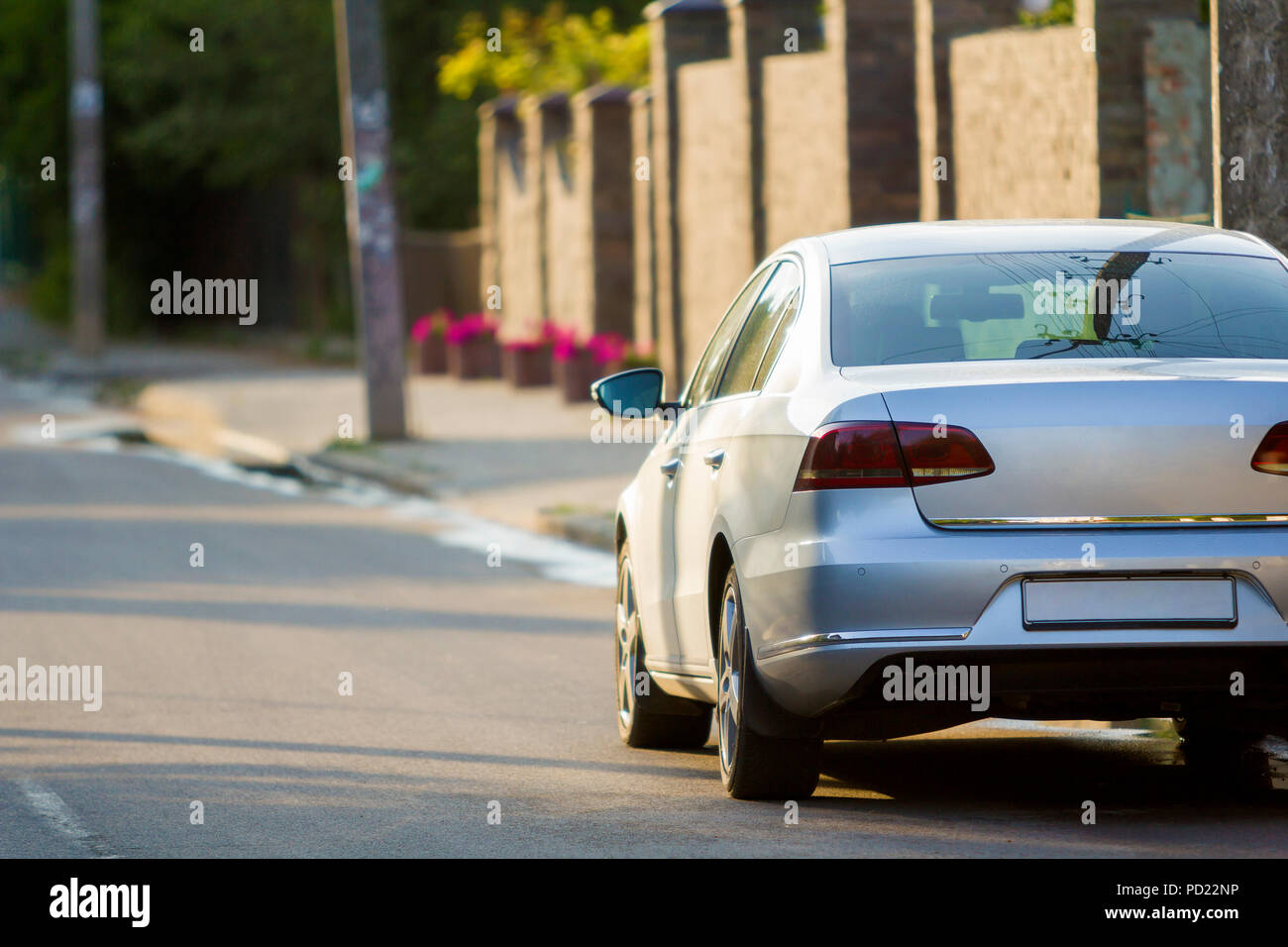 Close-up back view of new shiny expensive silver car moving along city ...