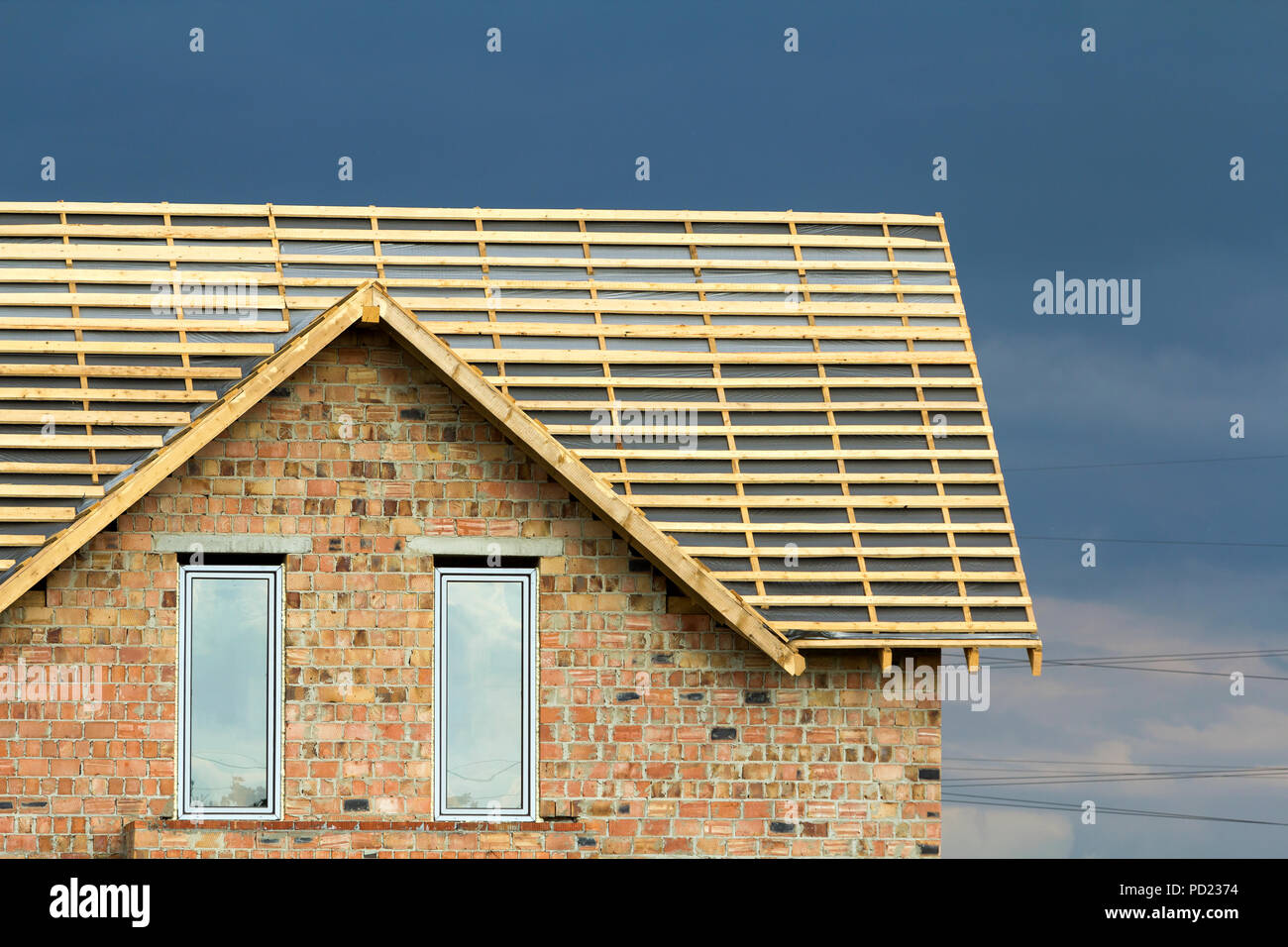 Close-up detail of new brick house top with two narrow plastic attic ...