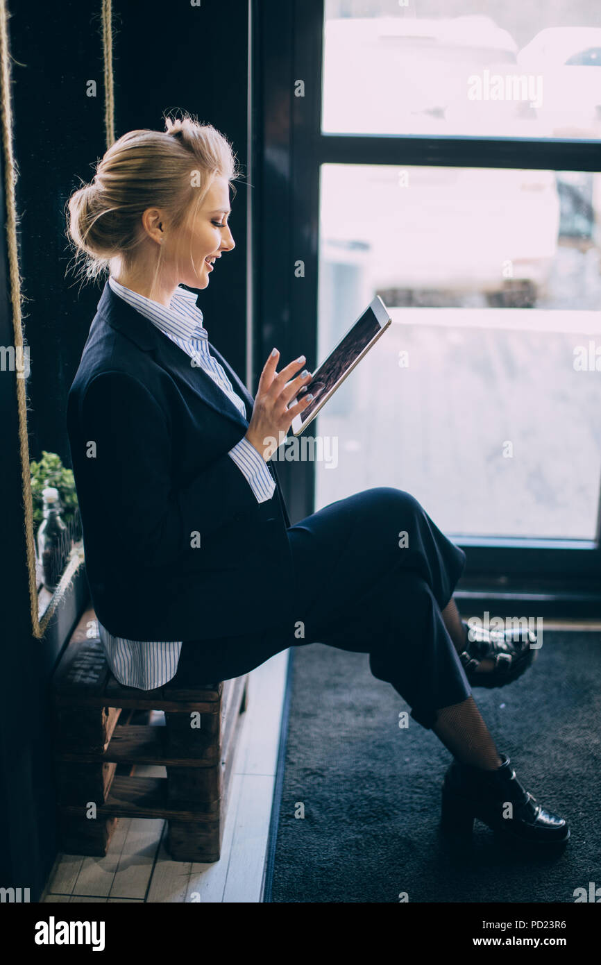 beautiful journalist dressed in formal clothes is working with tablet ...