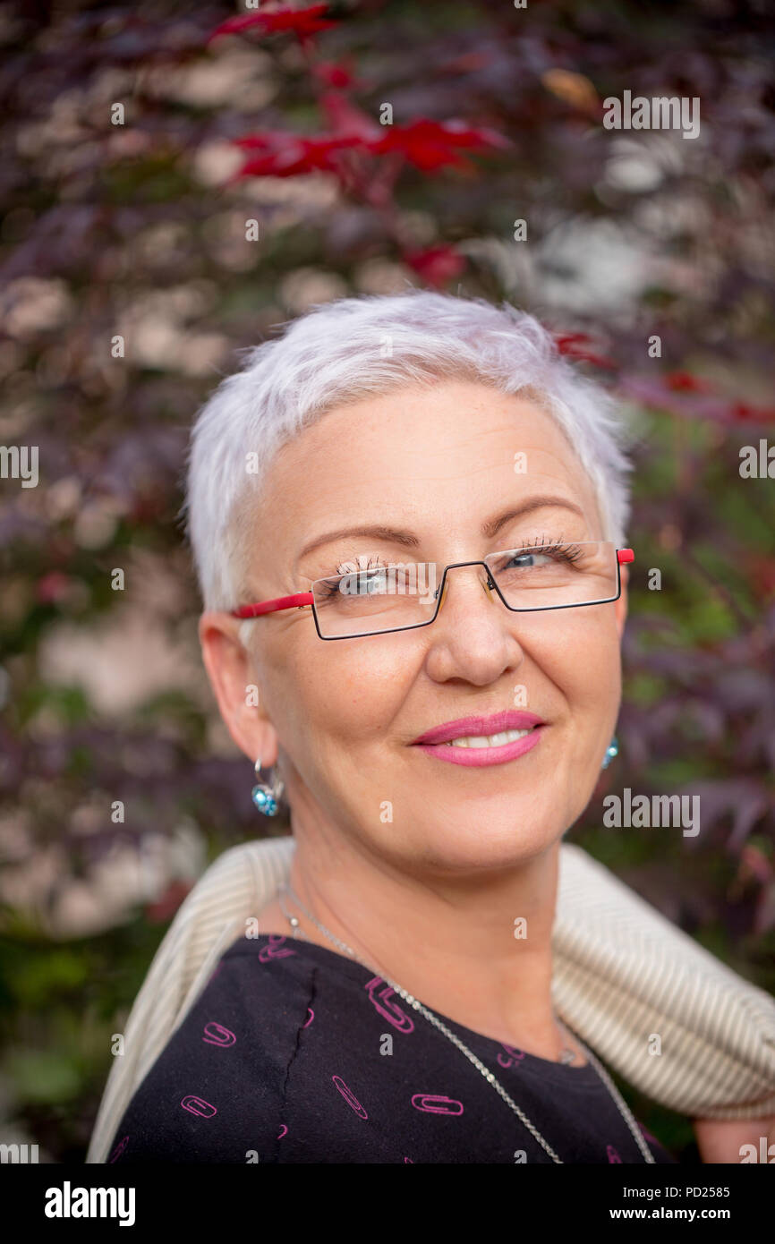 close up cropped photo of a maturewoman with short hairstyle and bright ...