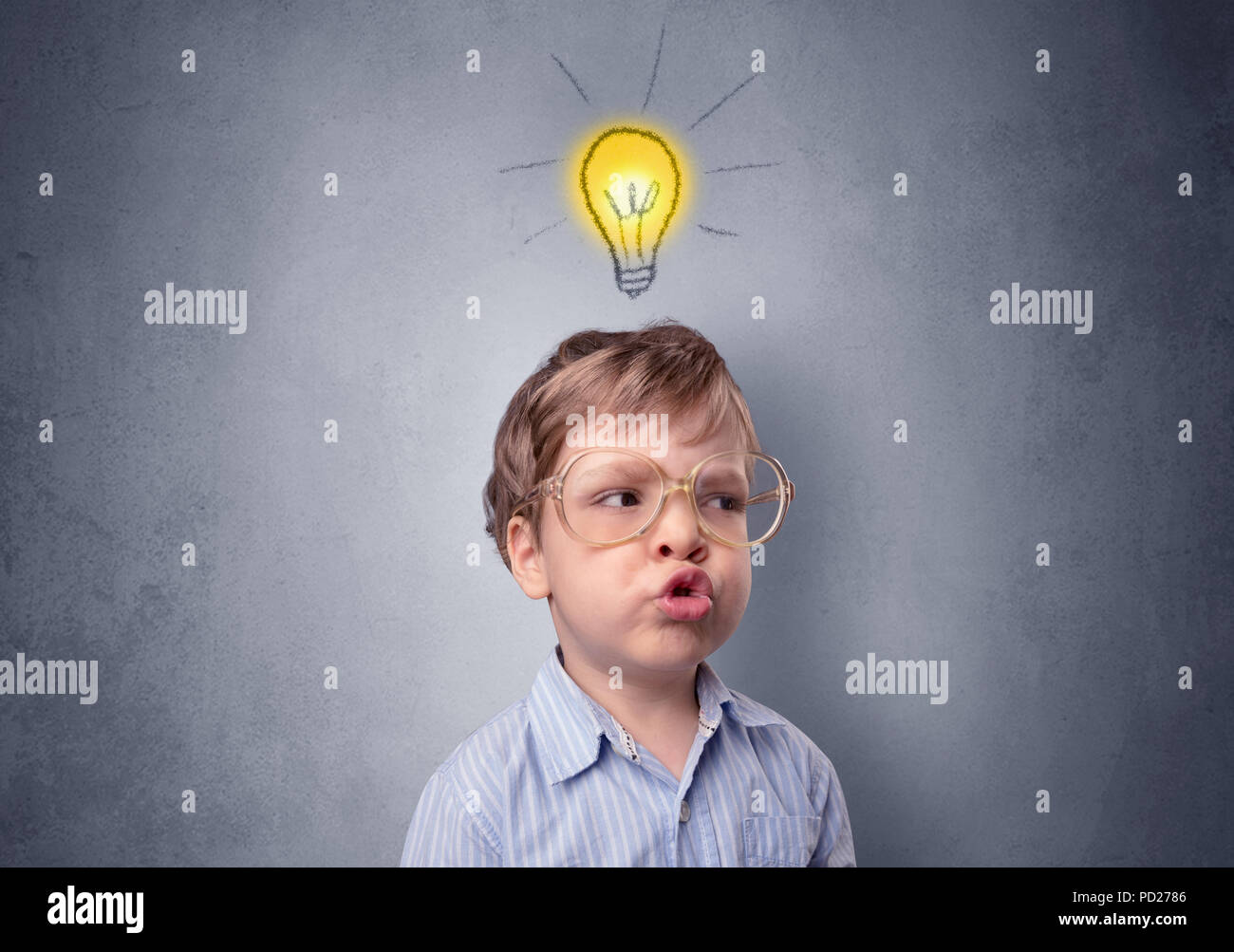Adorable little kid mull over in front of a grey wall with idea symbol ...