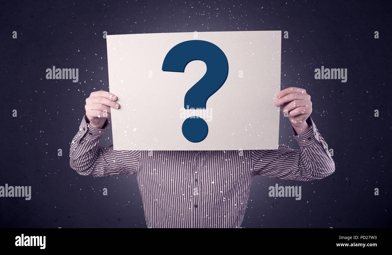 Young businessman hiding behind a question mark drawn on paper Stock ...