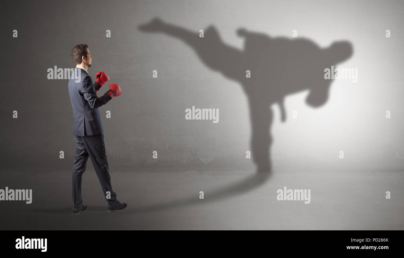 Businessman fighting with his strong karate man shadow Stock Photo - Alamy