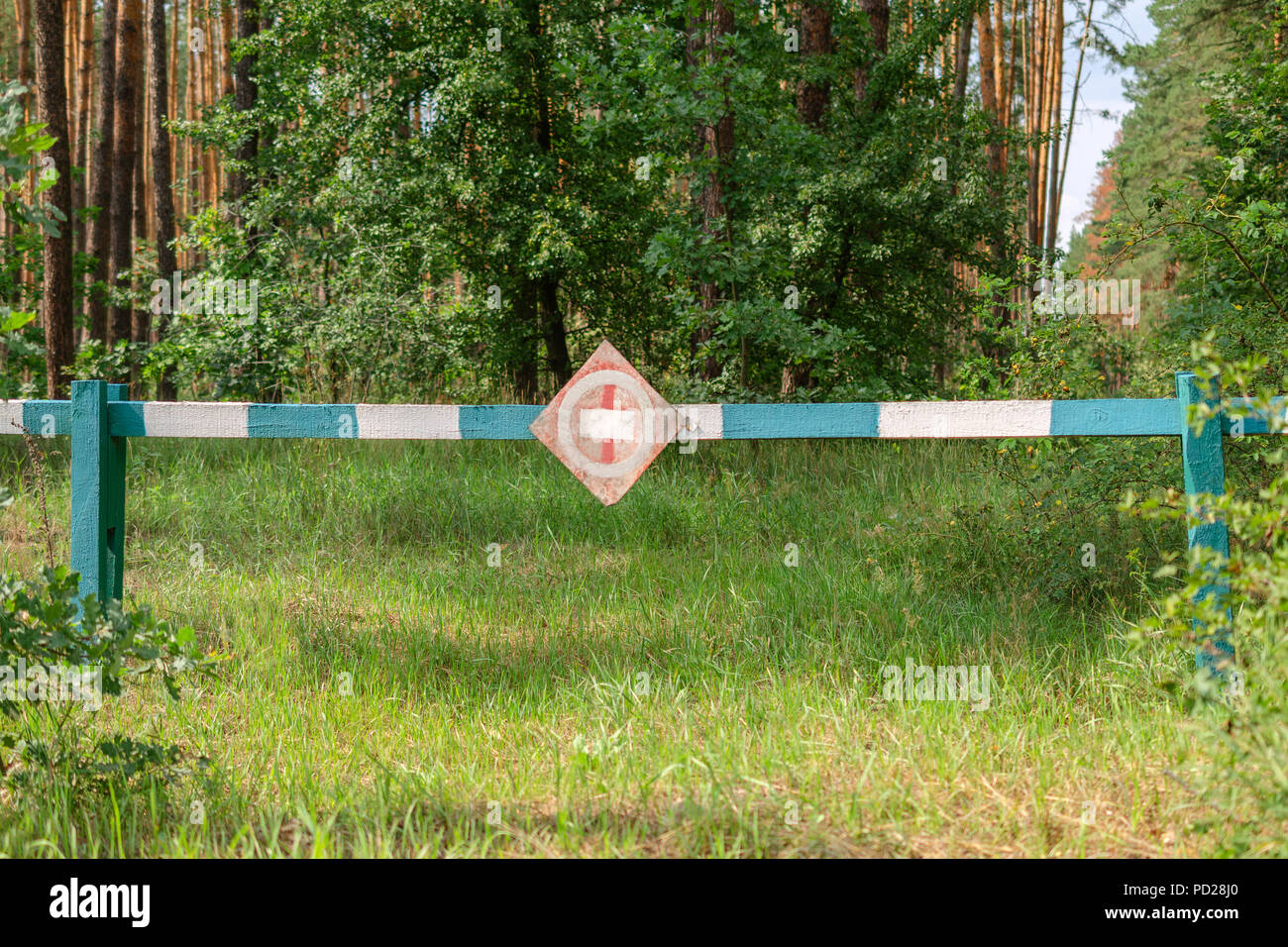 Territorial sign. Wooden green and white barrier striped in the forest ...