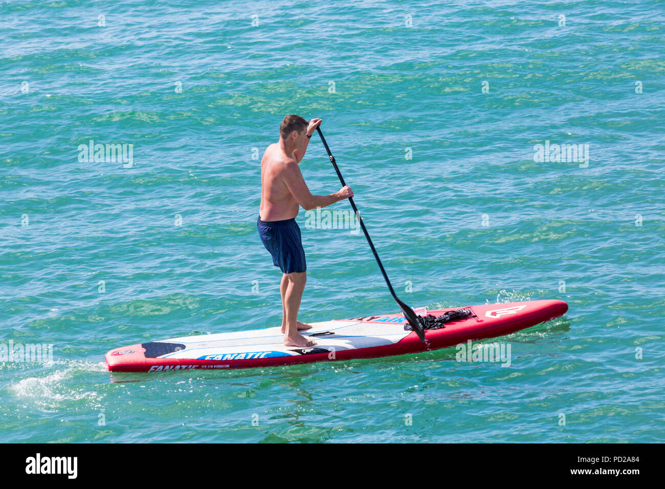 Stand up paddleboarder, paddle boarder, at Bournemouth, Dorset on a hot ...