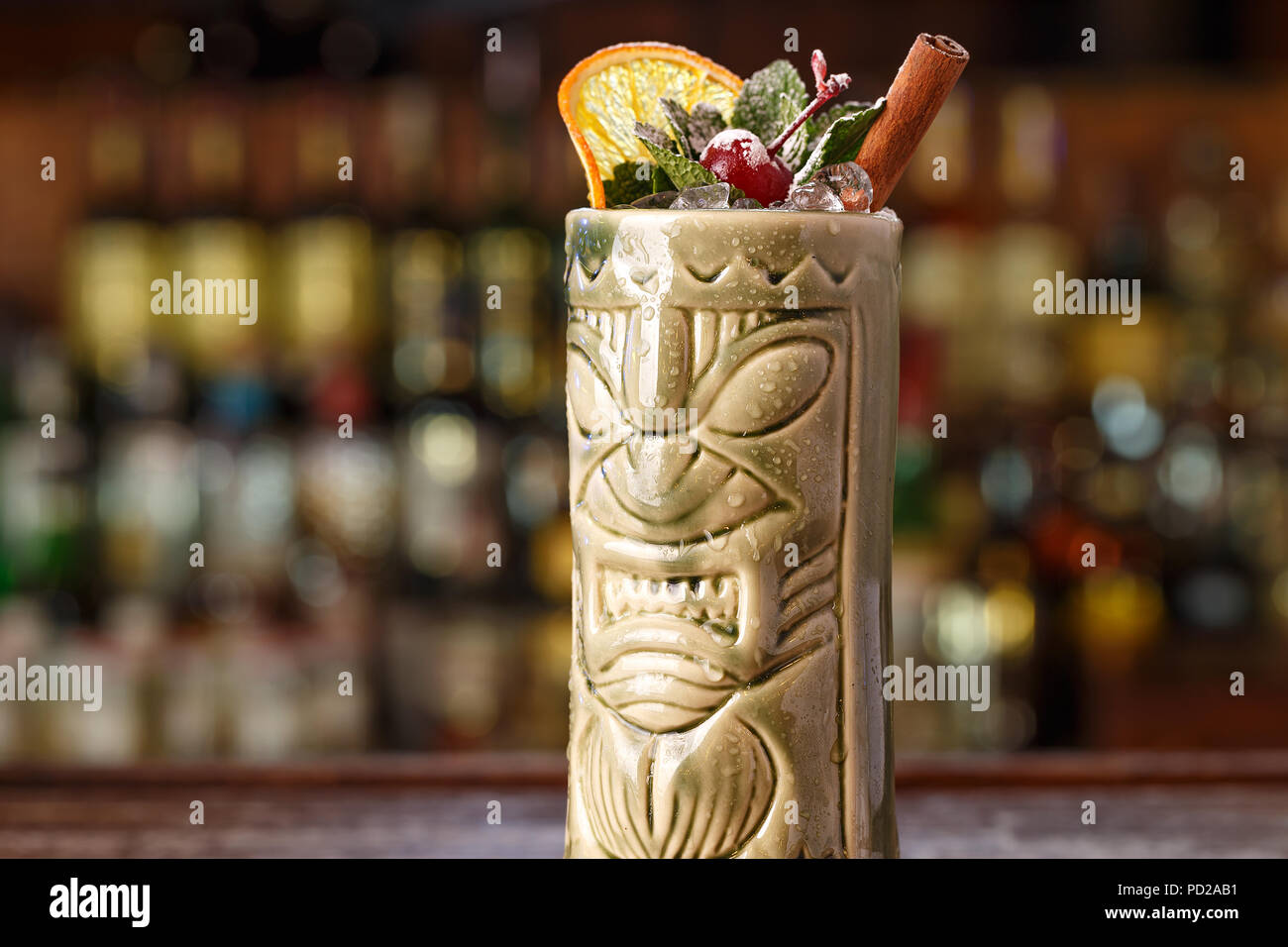 Refreshing alcoholic summer cocktail in tiki glass is in the bar in the ...