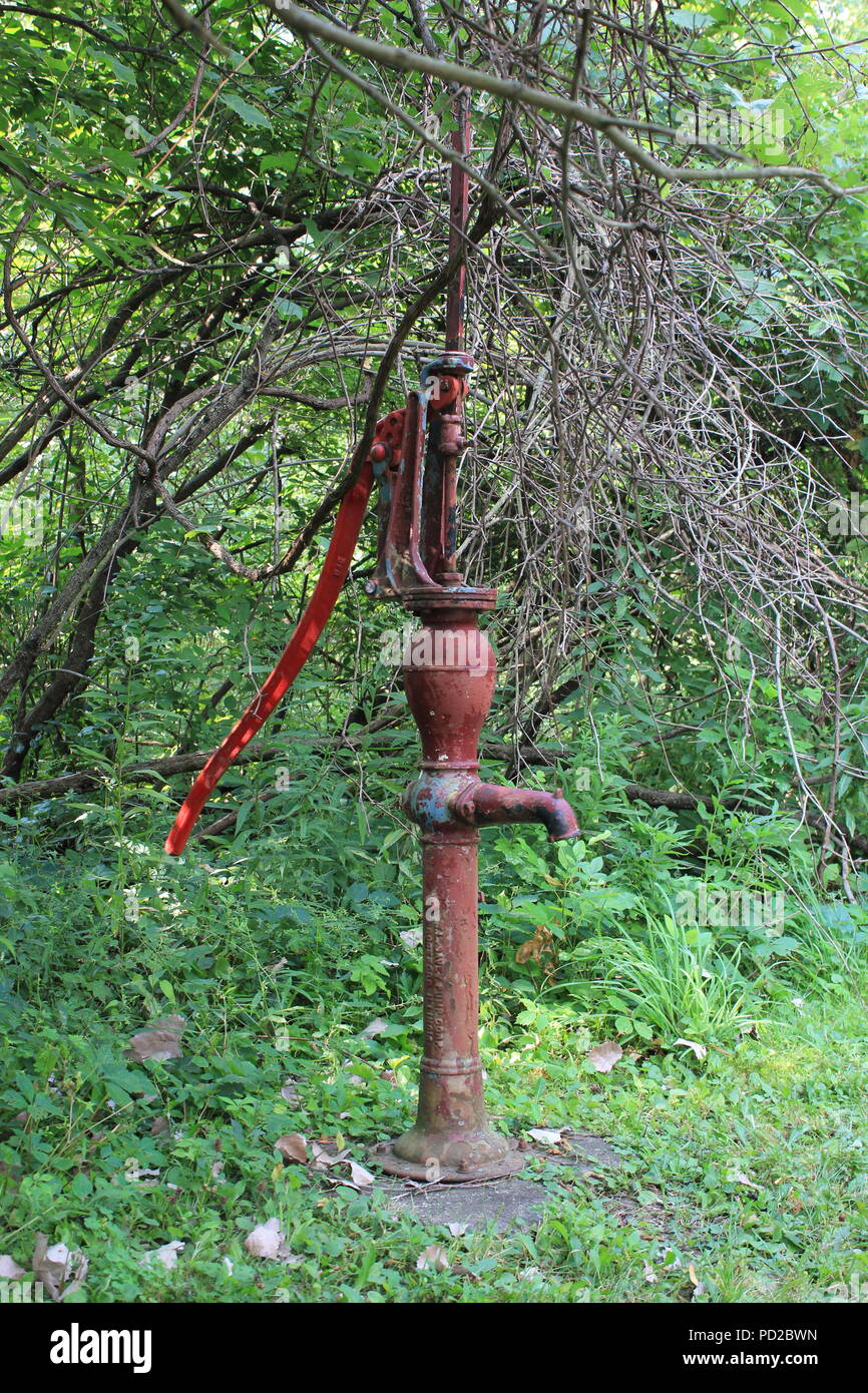 Vintage and authentic red hand powered water pump Stock Photo - Alamy