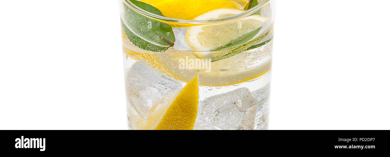 A full jug of drink from ice, lobules of fresh yellow lemon and crystal ...