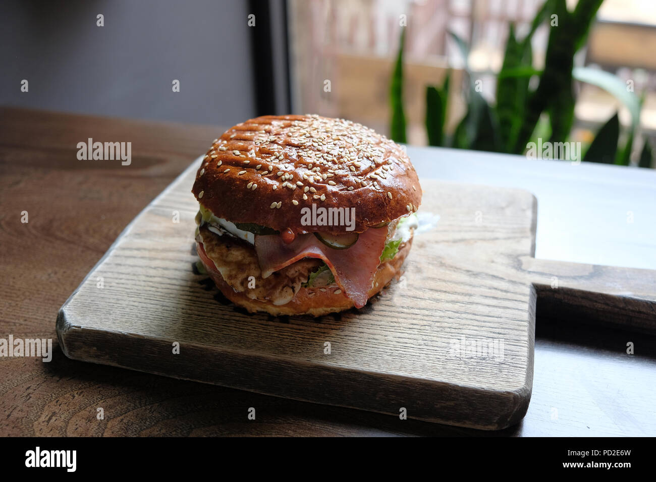 Craft beef burger on wooden table in cafe in front of window Stock ...