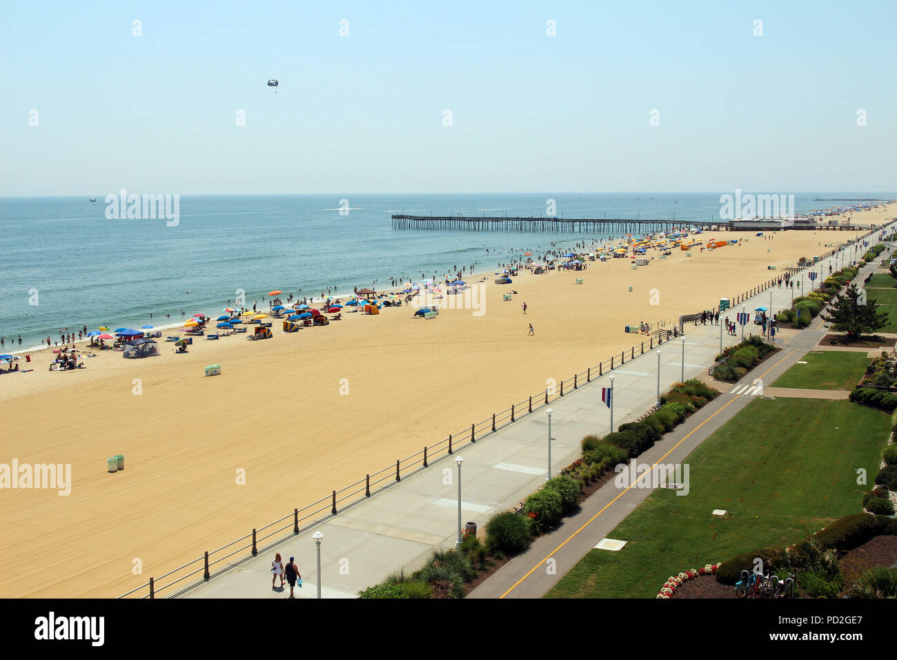 A perspective view of the beach, boardwalk, and pier with people ...