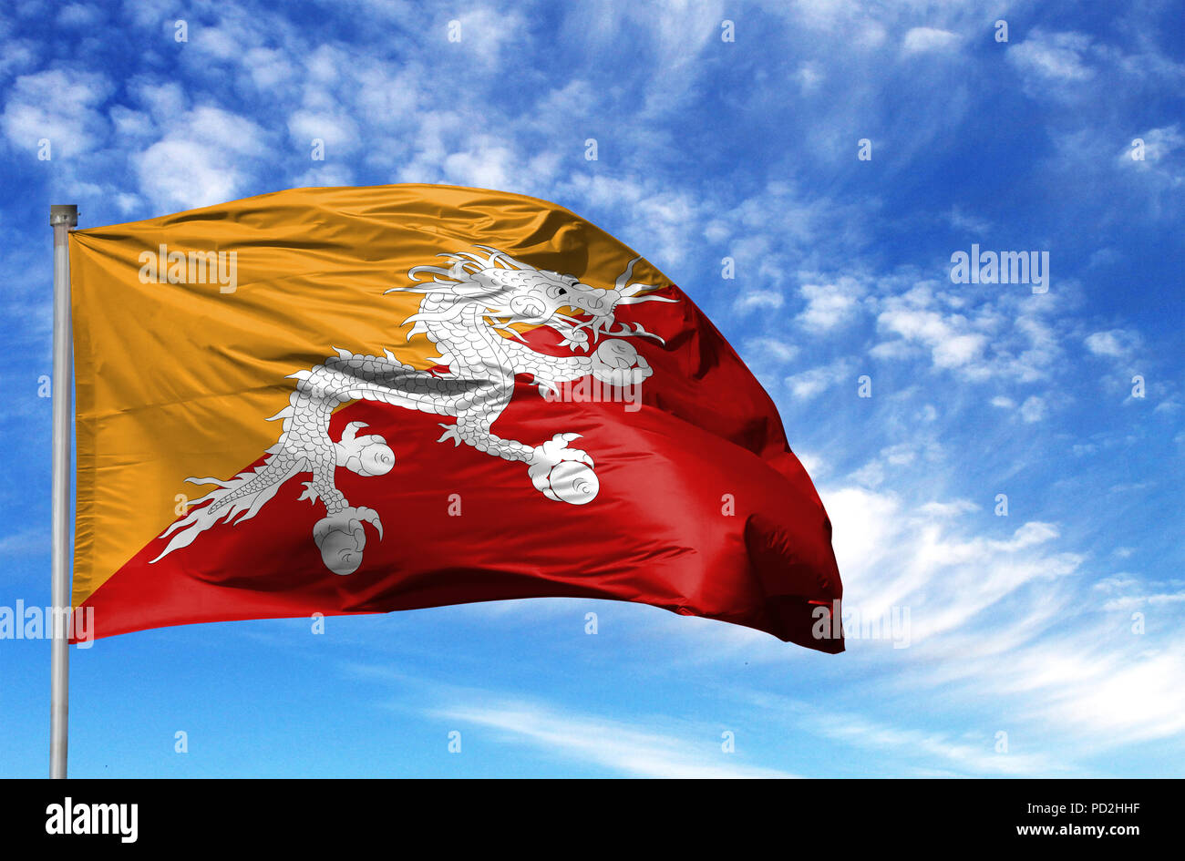 National flag of Butane on a flagpole in front of blue sky Stock Photo ...