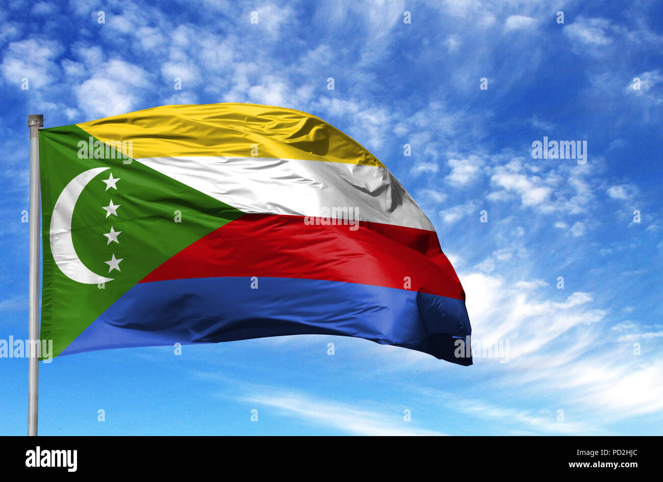 National flag of Comoros on a flagpole in front of blue sky Stock Photo ...