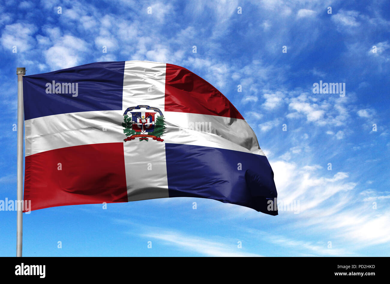 National flag of Dominican Republic on a flagpole in front of blue sky ...