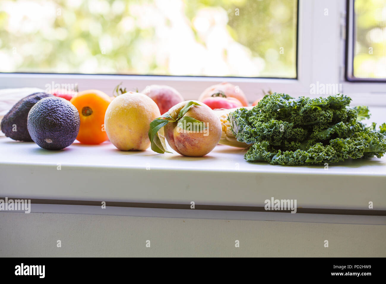Seasonal summer fruits and vegetables on the windowsill. Healthy clean ...