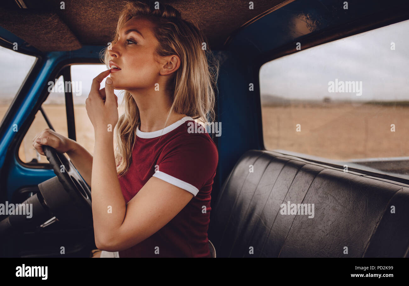 Woman looking into rear view mirror while driving a car. Beautiful ...