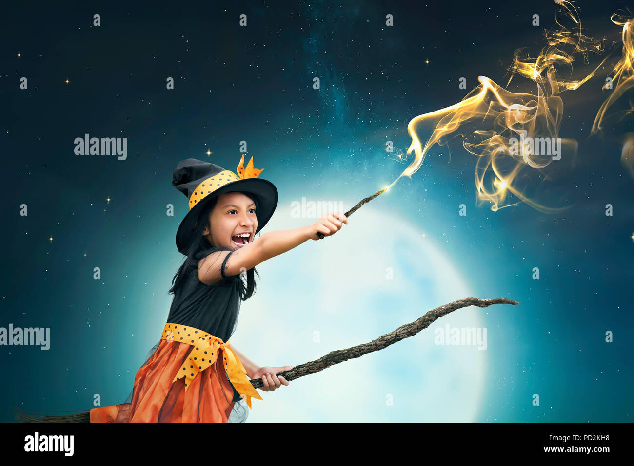 Beautiful asian witch girl using the magic wand with night background ...