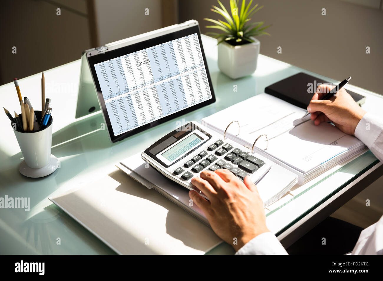 Close-up of a businessman's hand calculating invoice using calculator ...