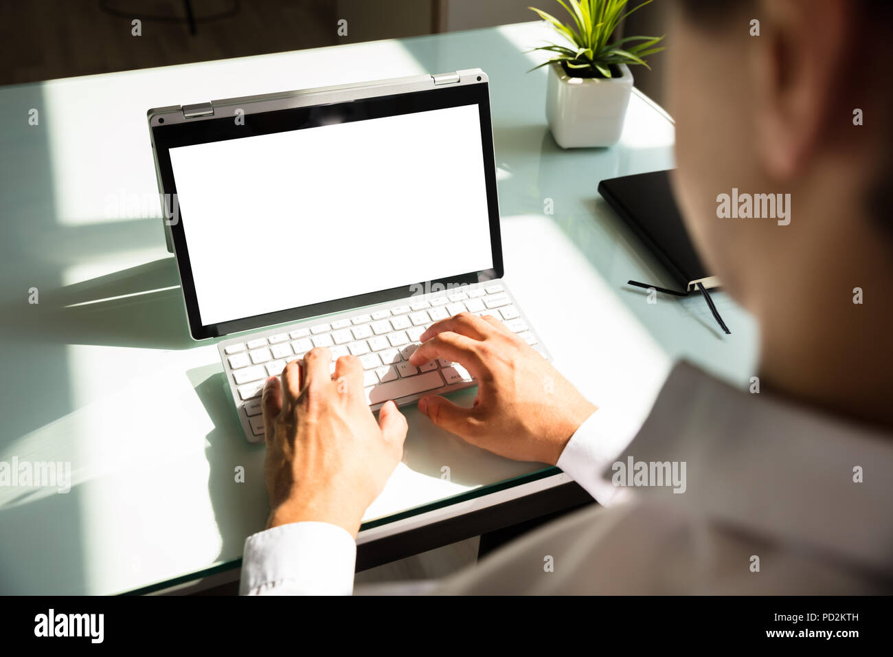 Close-up of a businessman's hand working on laptop with blank white ...