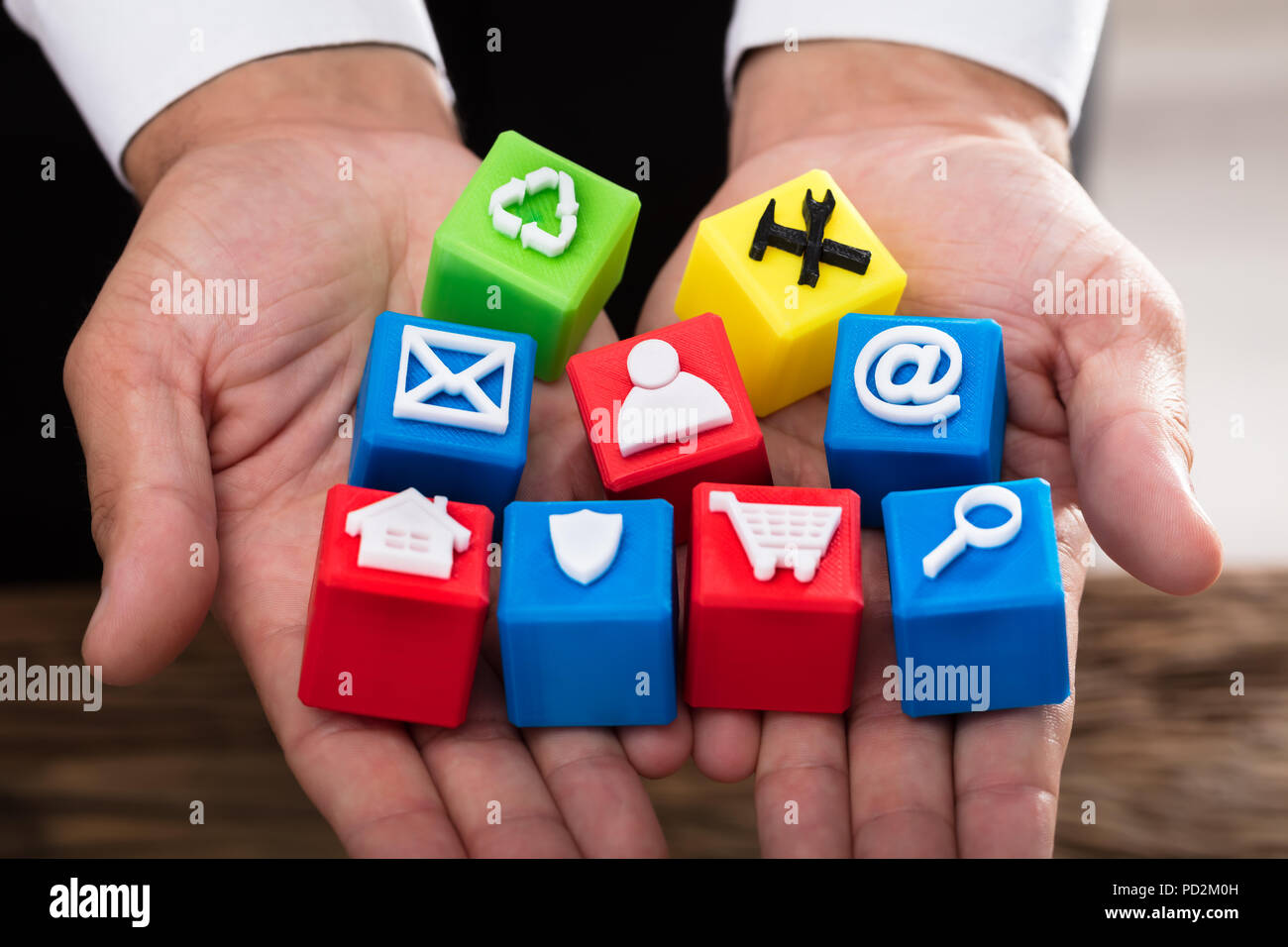 Elevated view of a man's hand holding cubic blocks with vivid icons ...