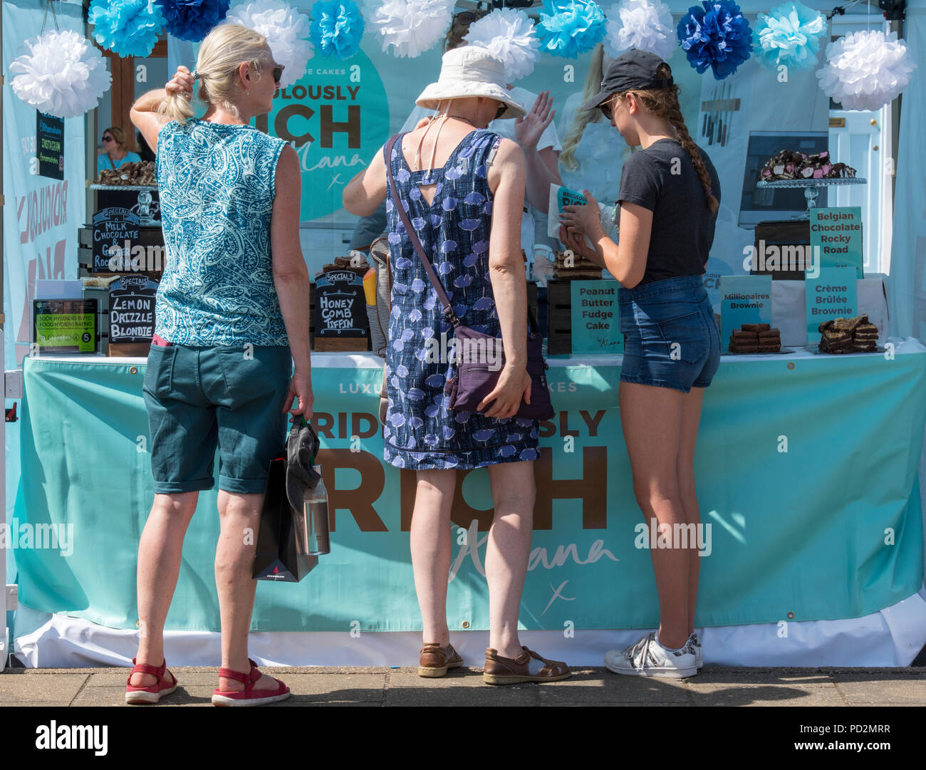 three women or ladies at a quality confectioners market stall or stand ...