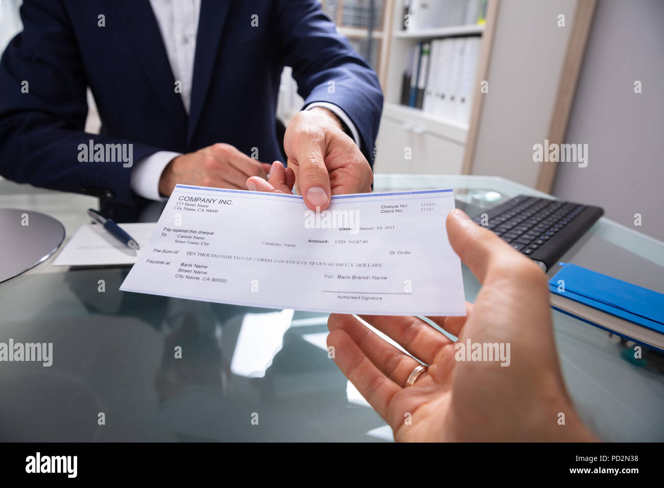 Businessman's Hand Giving Cheque Over Glass Desk Stock Photo - Alamy