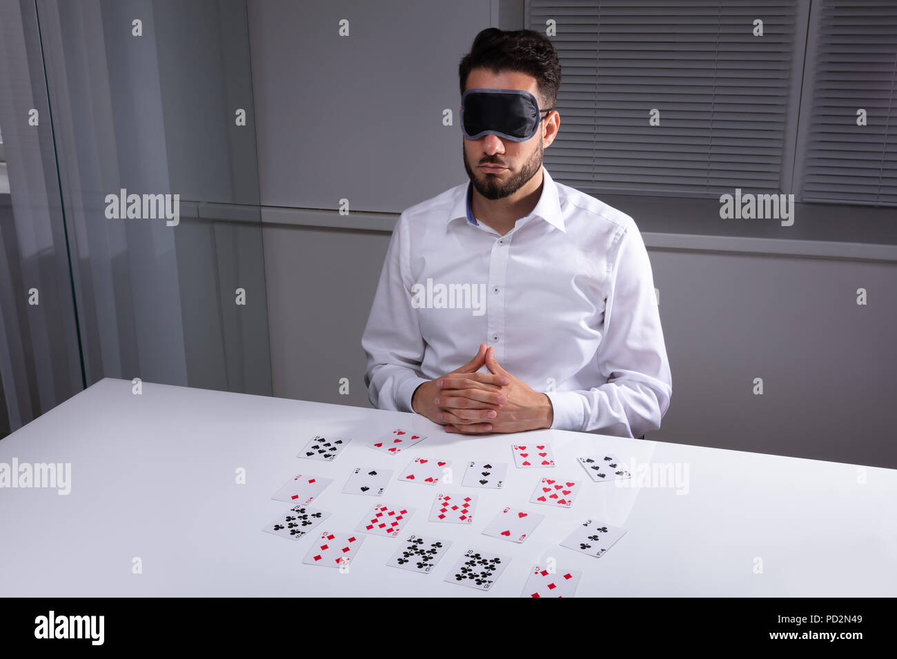 Blindfolded Businessman Reading Cards On White Desk Stock Photo - Alamy