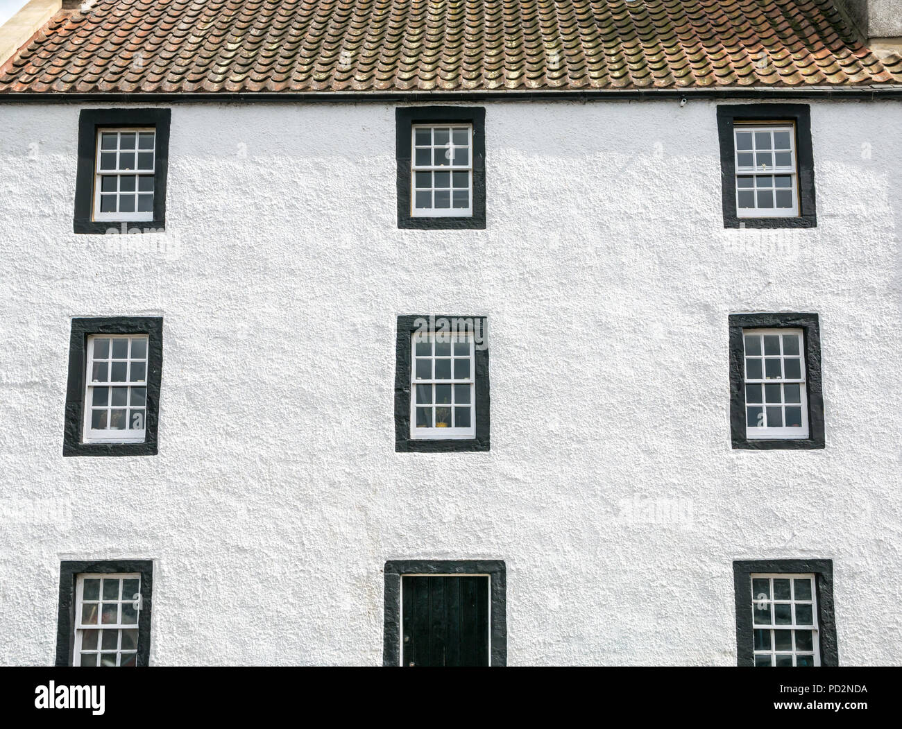 Old whitewashed tenement building with pantile roof and symmetrical ...